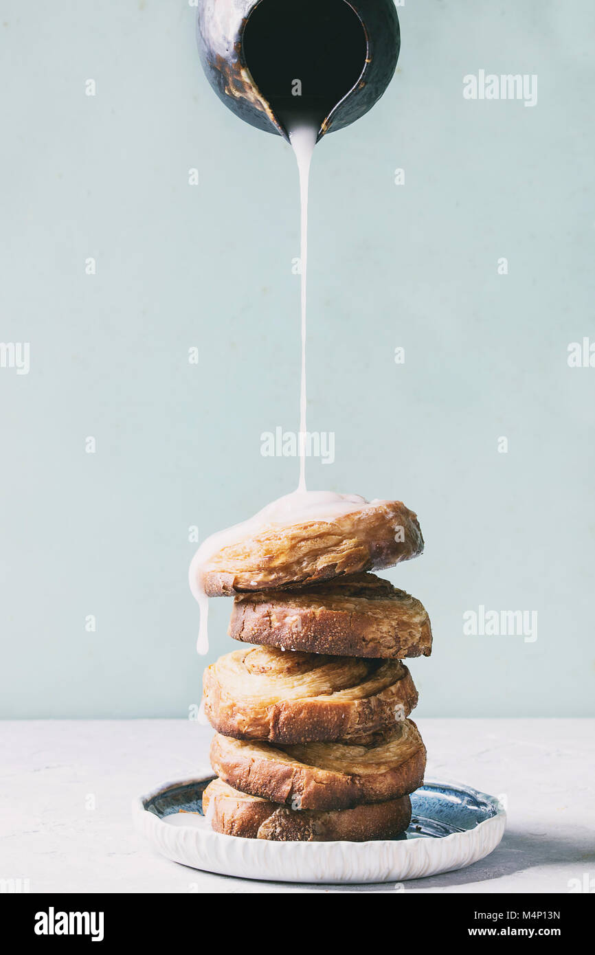 Stack of homemade glazed puff pastry cinnamon rolls with custard and ...