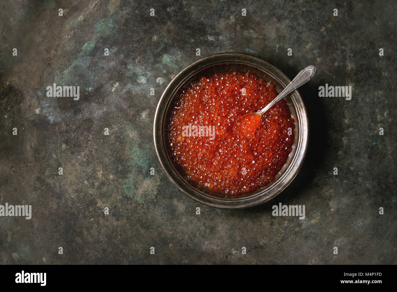 Vintage bowl of red caviar over old dark metal background. Top view ...