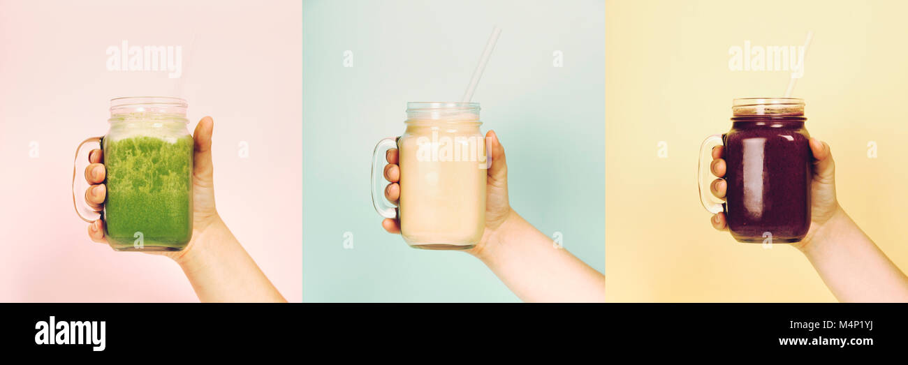 Womans hand holding smoothie shake against bright wall - collage Stock ...