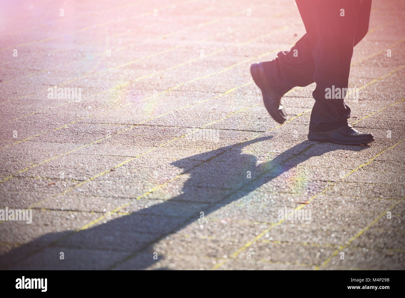 Man walking on sidewalk Stock Photo - Alamy