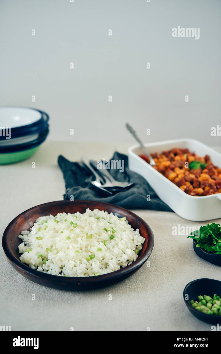 Simple fried rice in a dark ceramic dish on a dinner table photographed ...