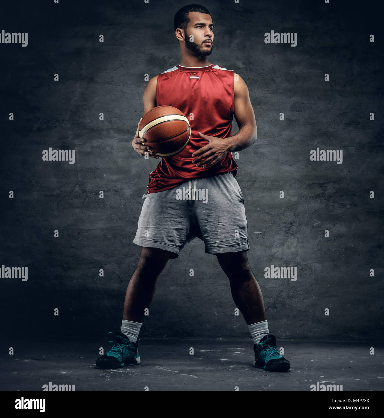 Full body studio portrait of a black basketball player playing with a ...