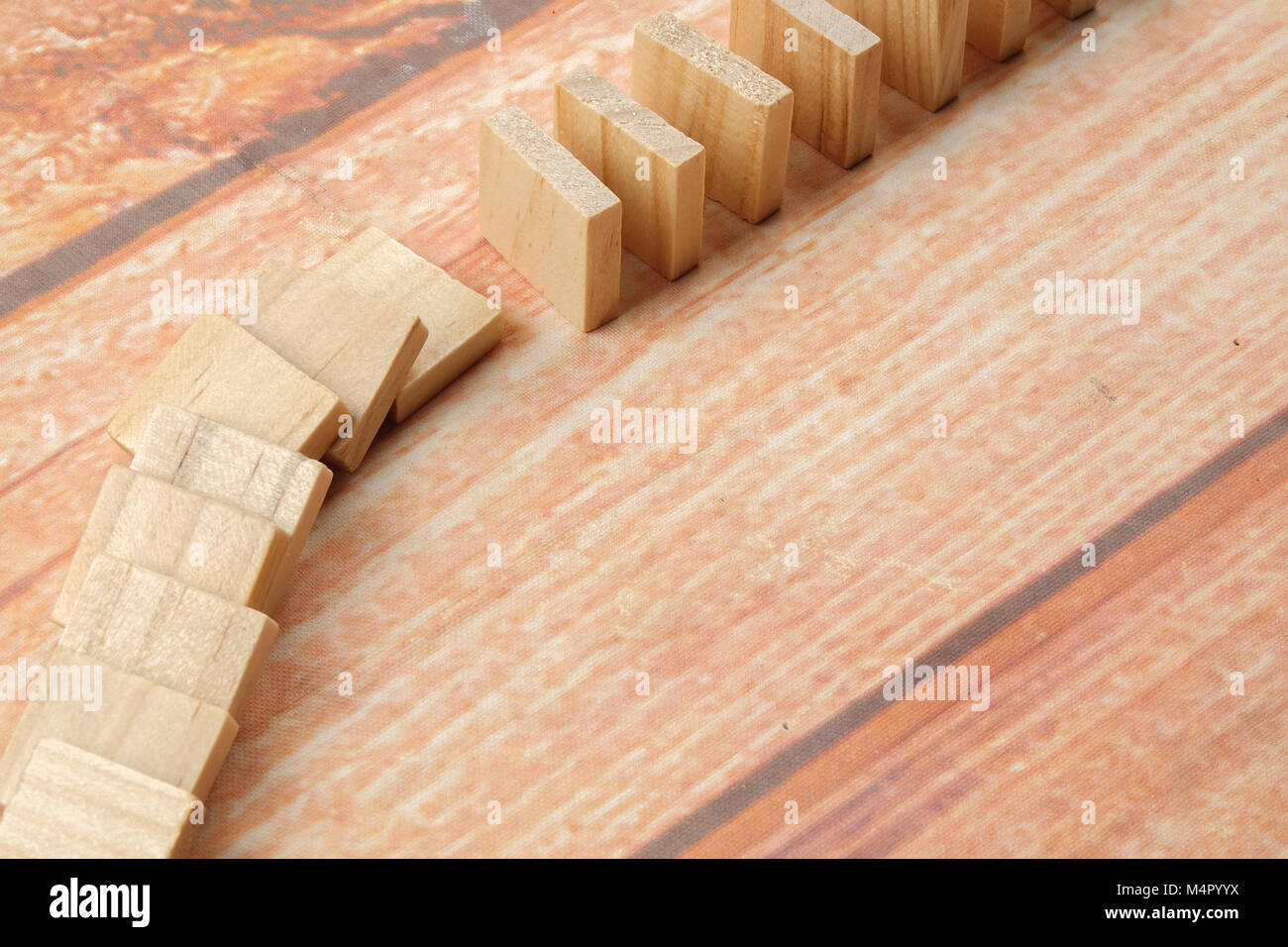 Domino effect isolated on wooden background Stock Photo - Alamy