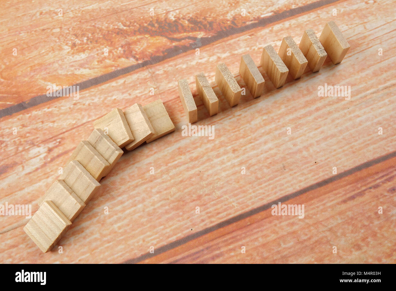 Domino effect isolated on wooden background Stock Photo - Alamy