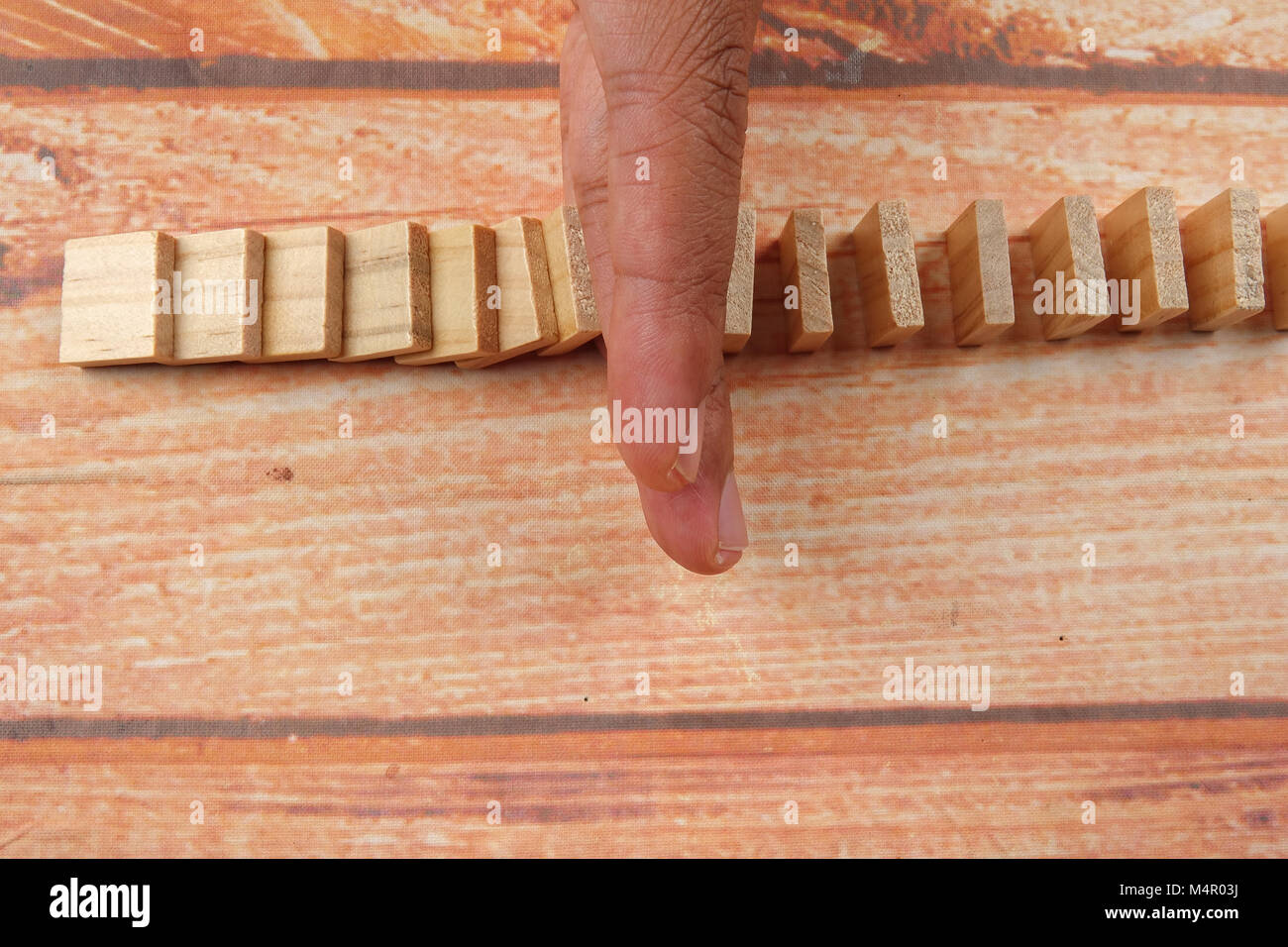 Domino effect isolated on wooden background Stock Photo - Alamy