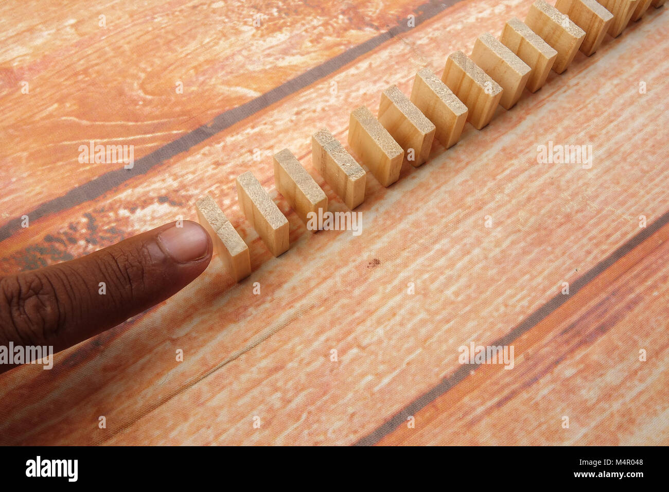 Domino effect isolated on wooden background Stock Photo - Alamy