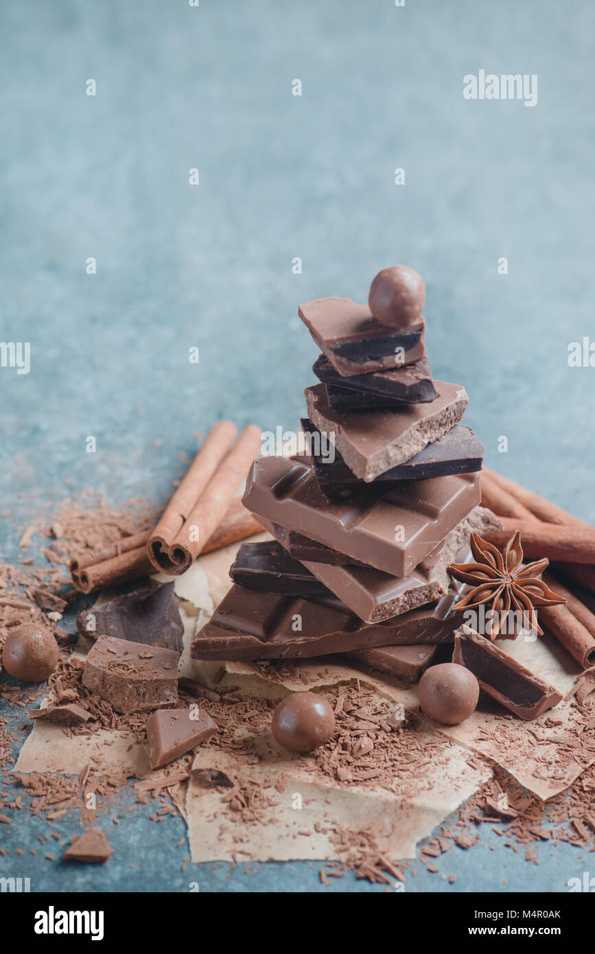 Pile of broken chocolate pieces on a marble kitchen table. Making a ...