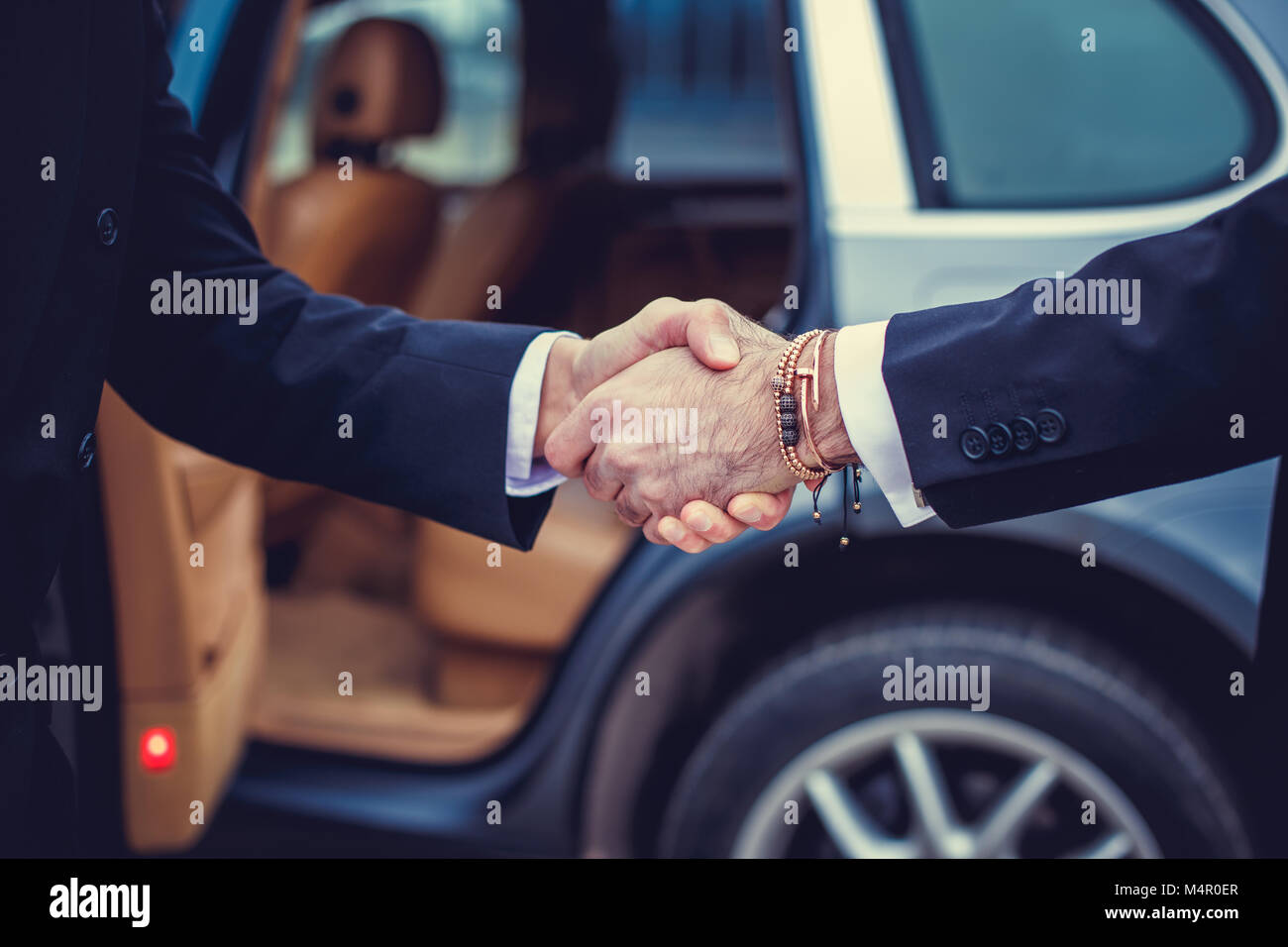 Two men handshake in front of the car Stock Photo - Alamy