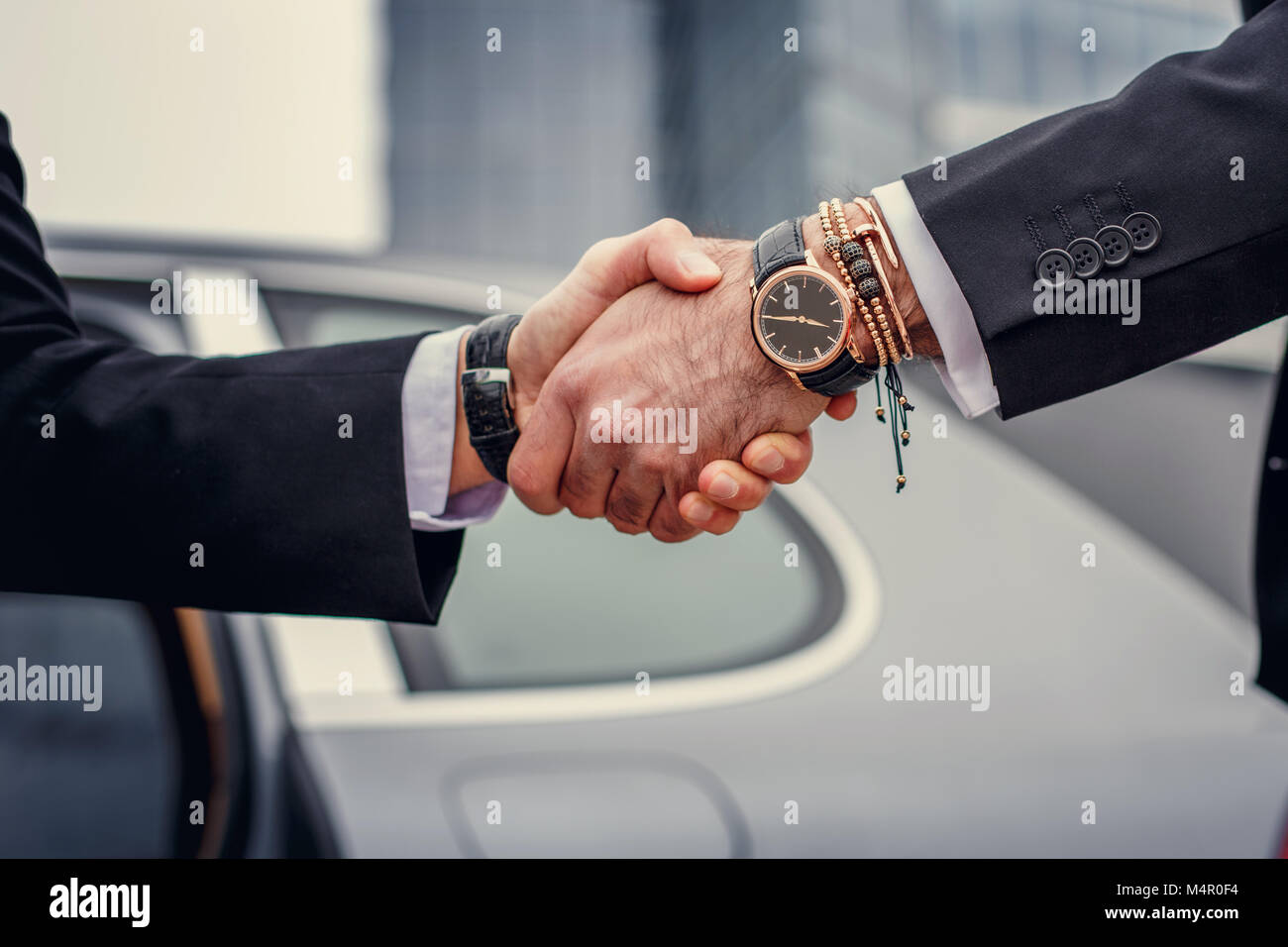 Two men handshake in front of the car Stock Photo - Alamy