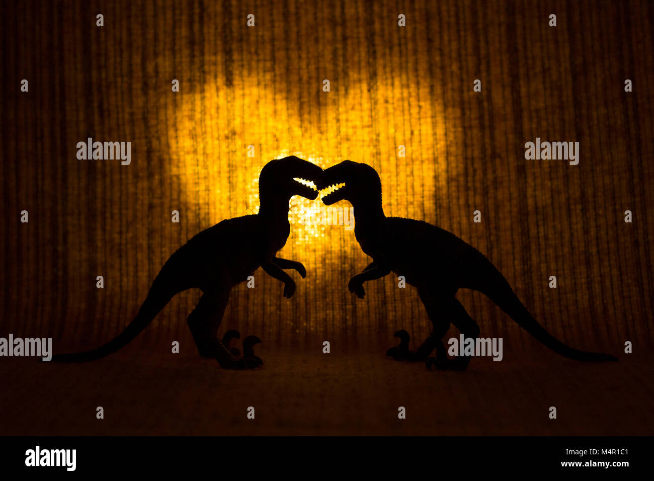 Two raptors - dinosaurs - in front of a glowing heart Stock Photo - Alamy