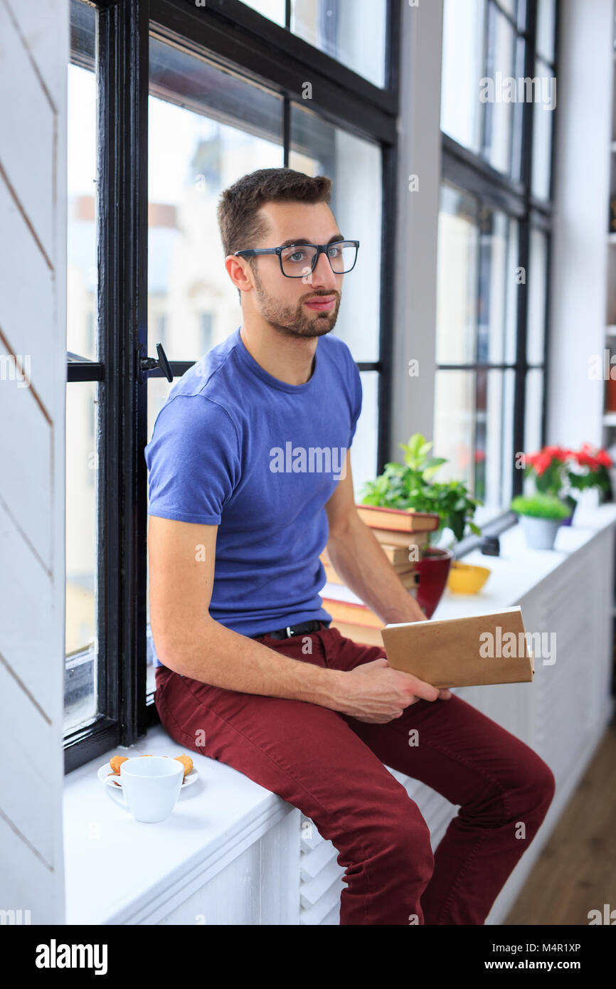 A smart man in eyeglasses reading the book Stock Photo - Alamy