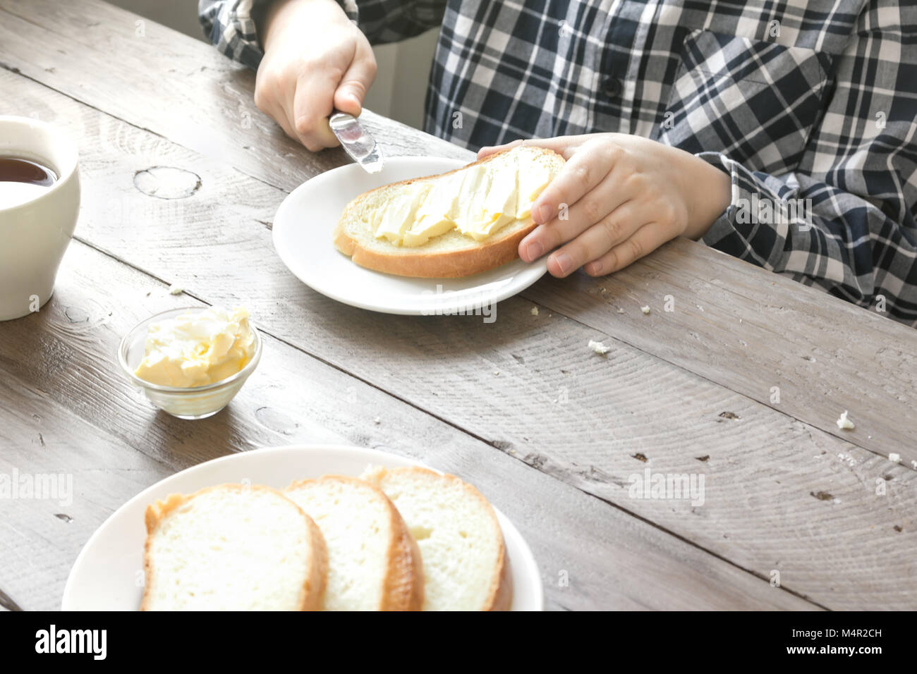 Male hands spreading butter on toasted bread while morning breakfast ...
