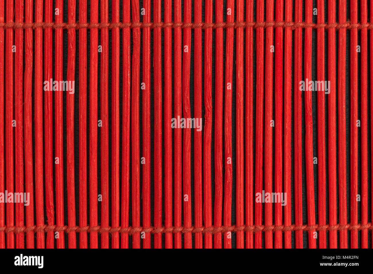 Red sticks in dark background. Red sticks tied up between each other ...