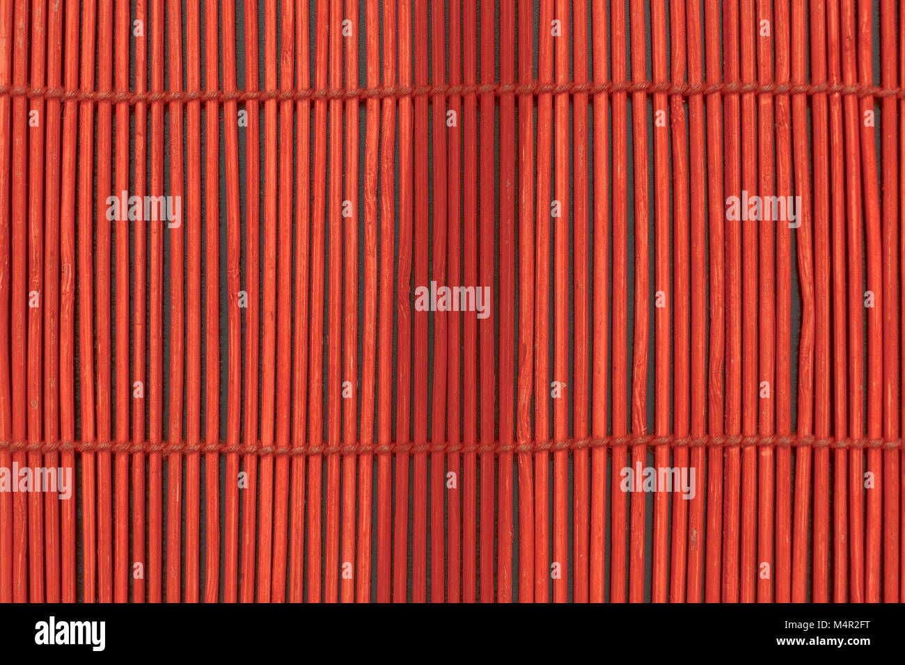 Red sticks in dark background. Red sticks tied up between each other ...