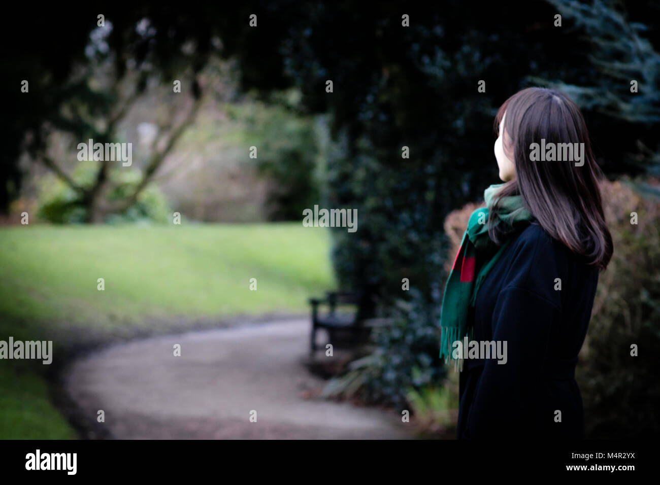 A beautiful young lady looking down a path, with copy space on the left ...