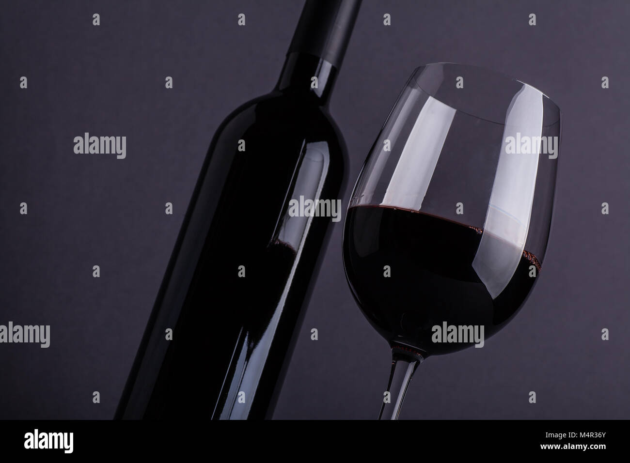 Bottle and glass of red wine over a dark gray background Stock Photo ...