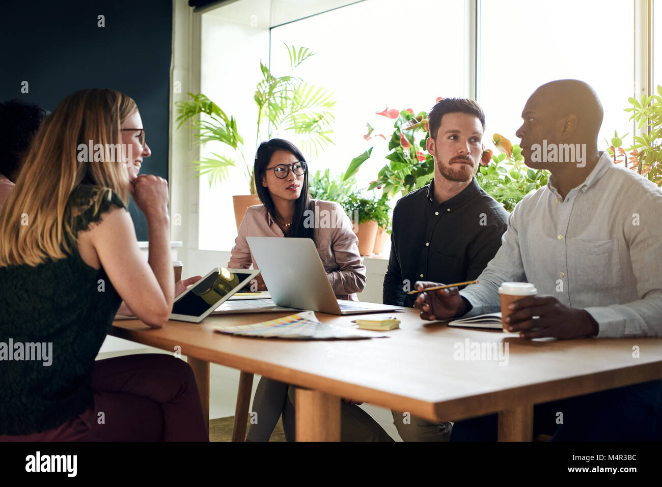 Group of focused designers having a meeting together while sitting ...