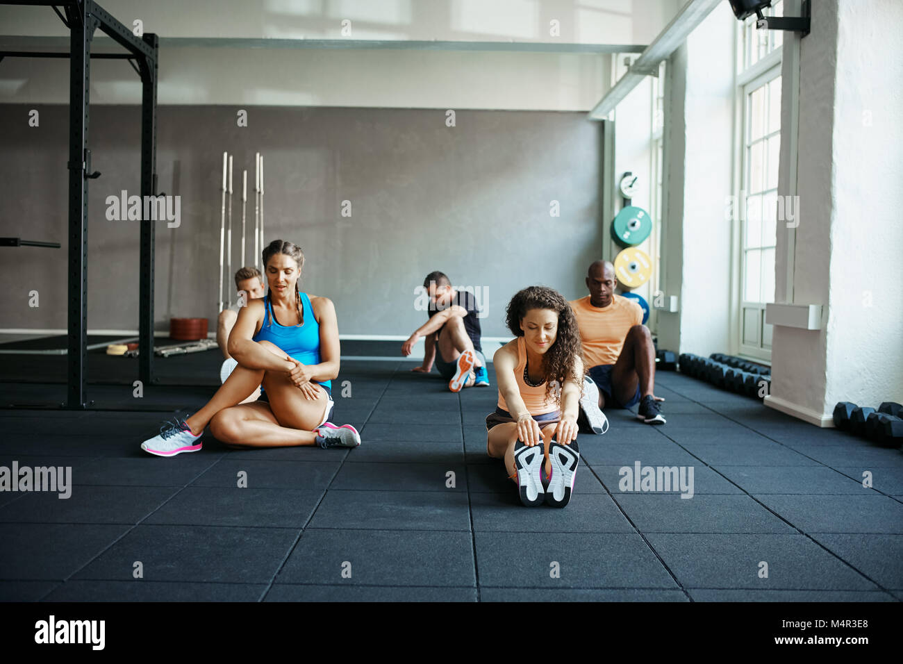 Diverse group of fit people in sportswear smiling and stretching ...