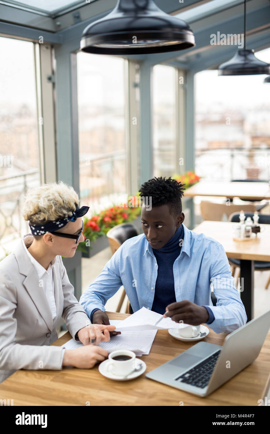 Group young colleagues discussing documents hi-res stock photography ...