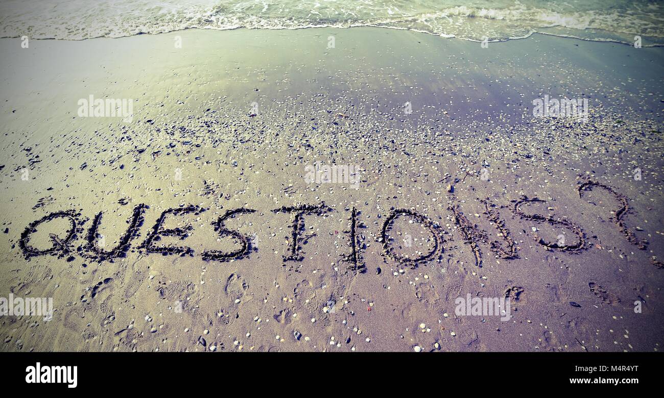 QUESTIONS written in the sand of the beach with vintage effect Stock ...