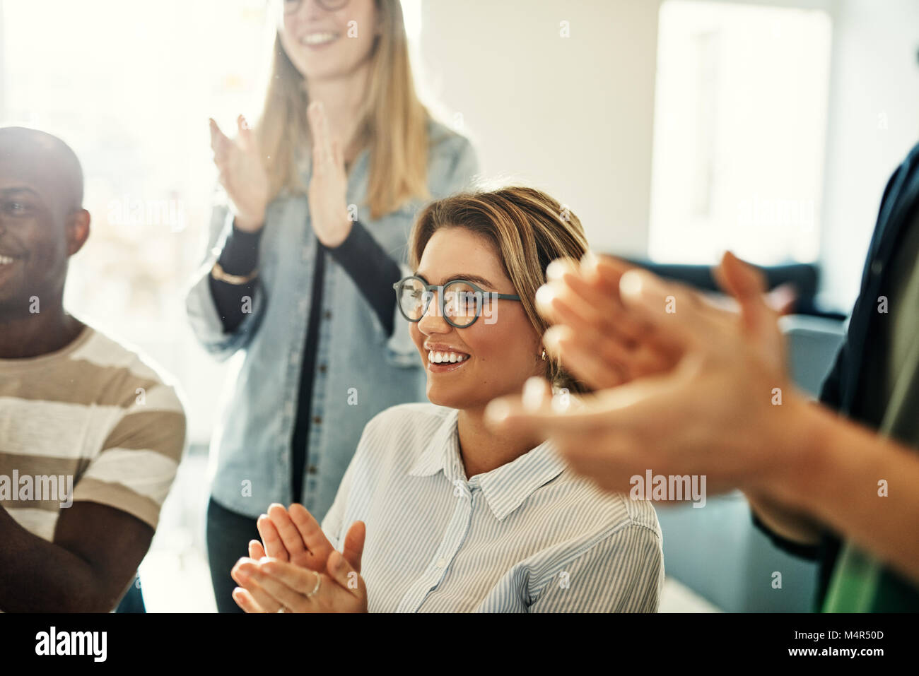 Group of diverse businesspeople smiling and clapping during a meeting ...