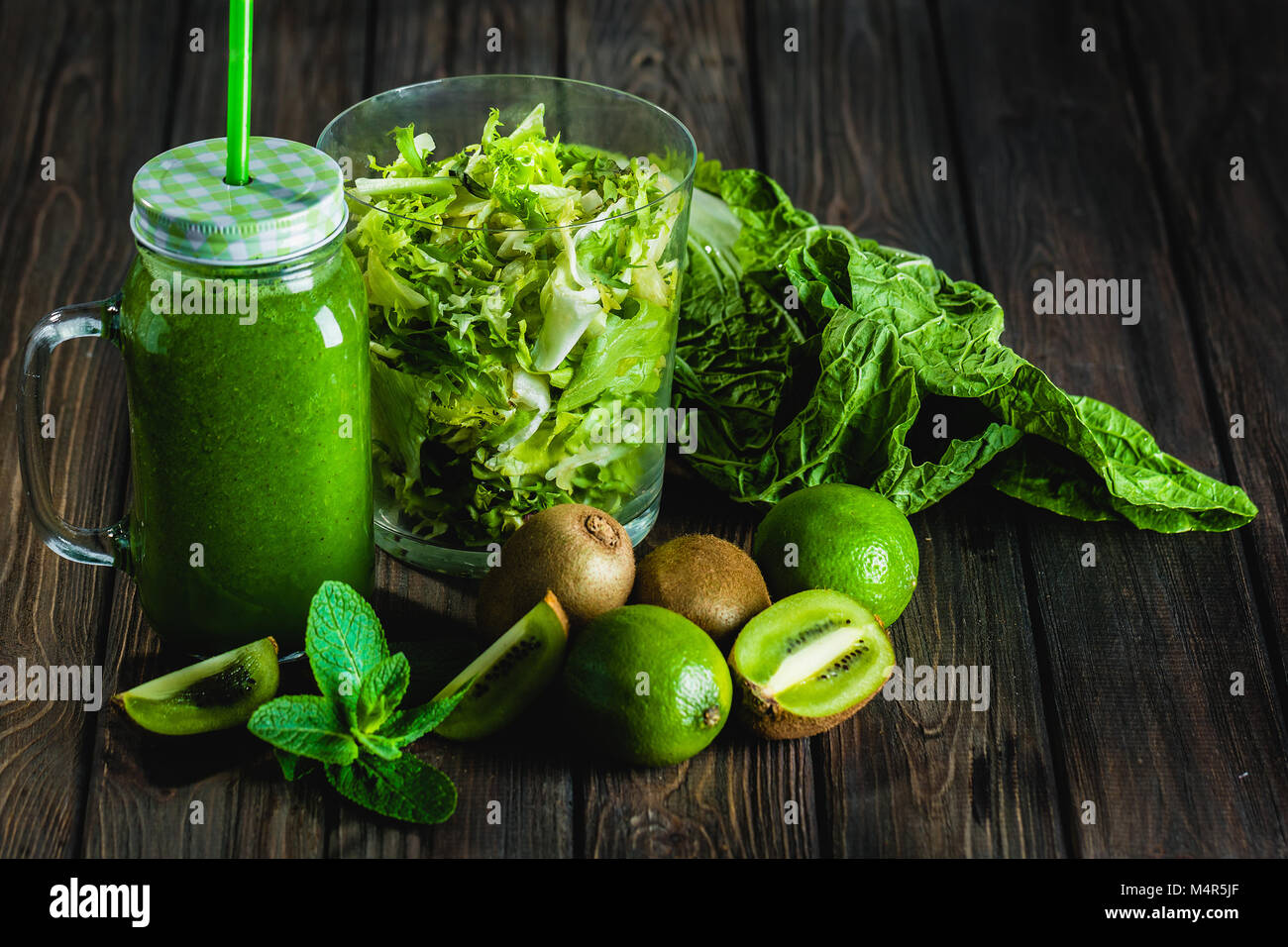 Blended green smoothie with ingredients on wooden table selective focus ...