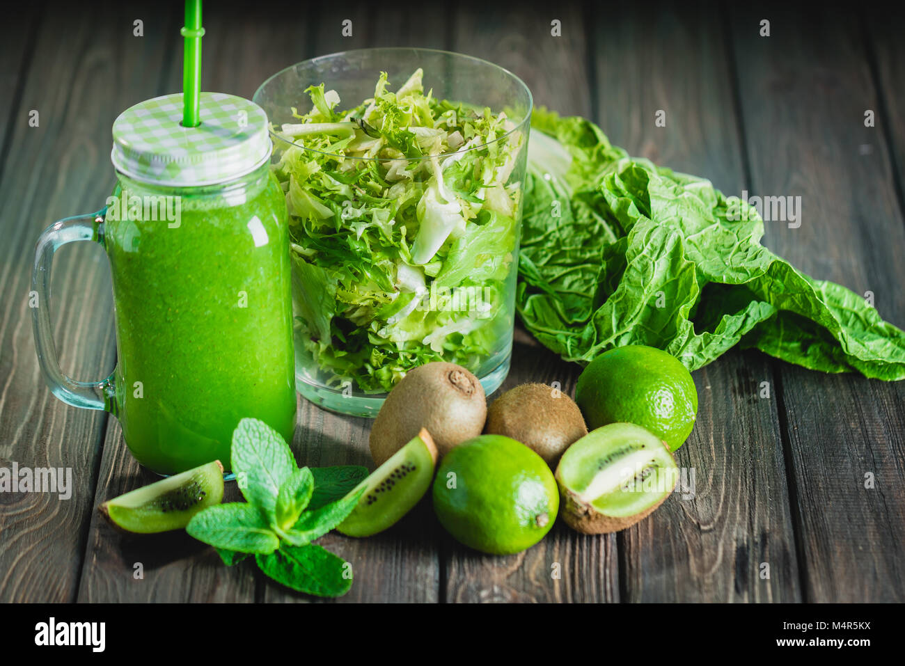 Blended green smoothie with ingredients on wooden table selective focus ...