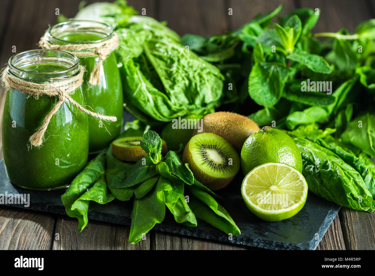 Blended green smoothie with ingredients on the stone board, wooden ...