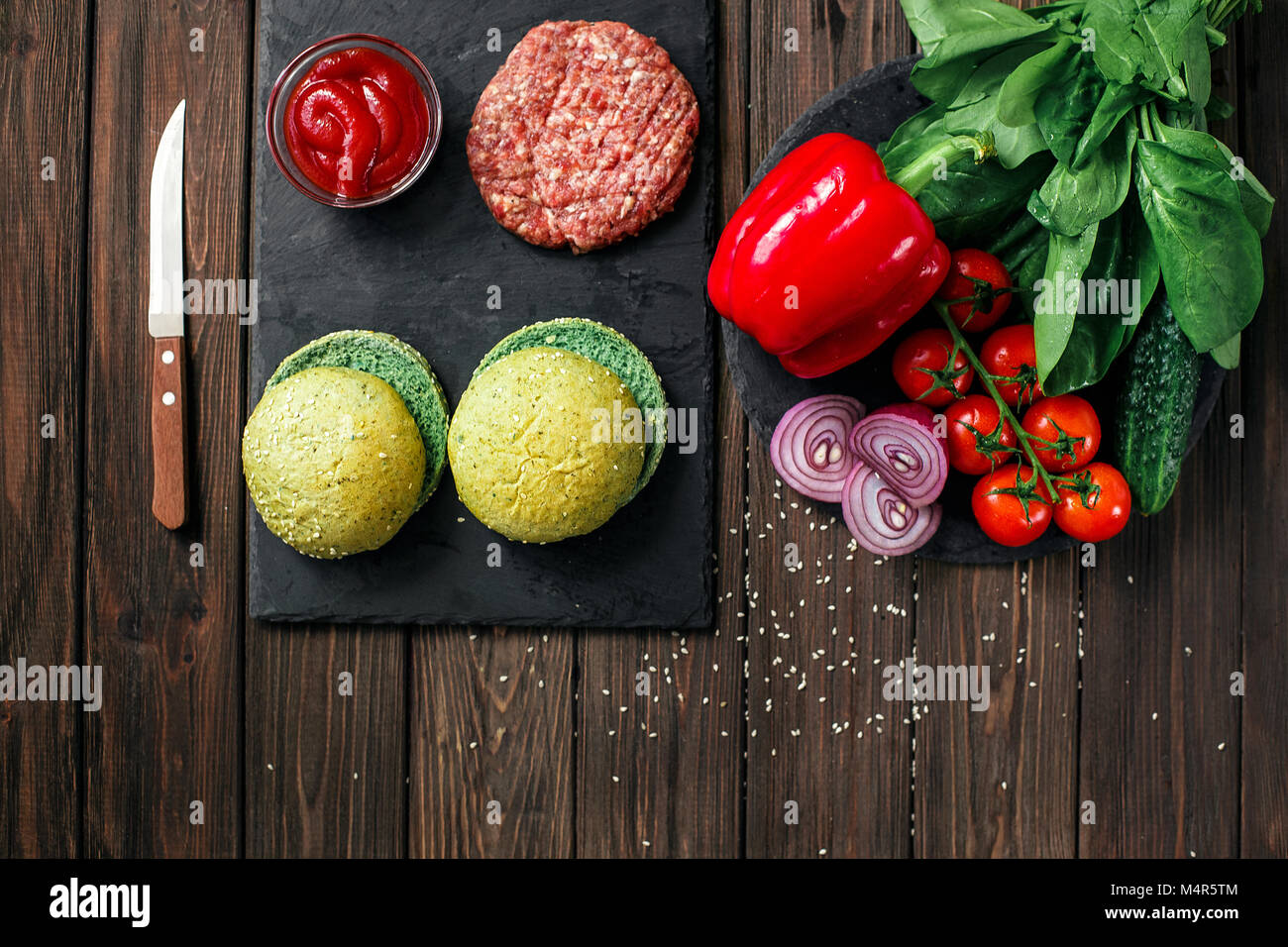 From above shot of process of making hamburger with vegetables, buns ...