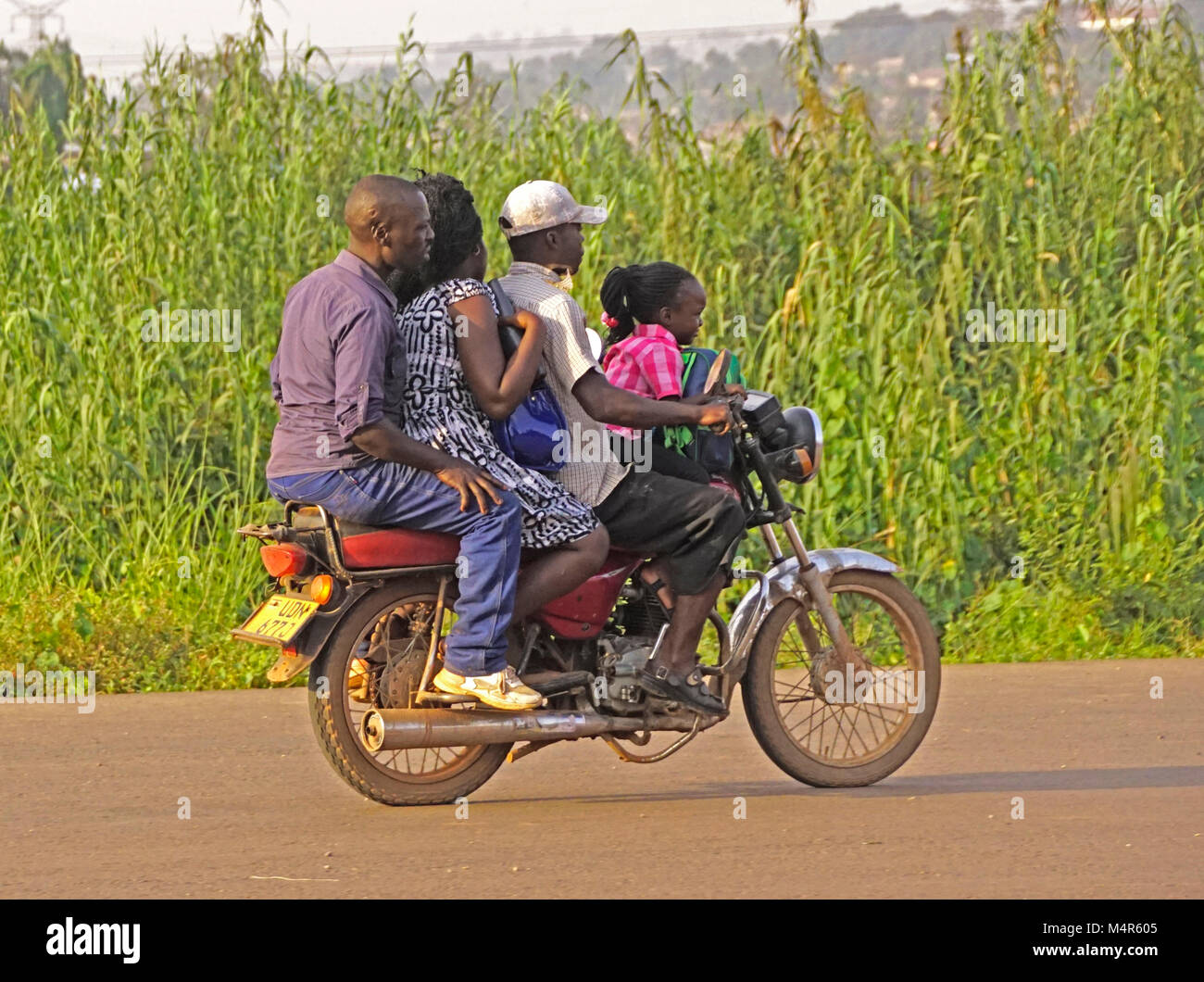 A boda-boda (motorcycle) carrying four near Kampala Stock Photo - Alamy