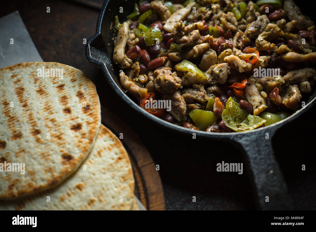 Tortilla on parchment and frying pan with filling side view horizontal ...