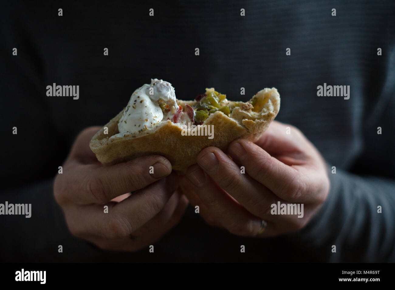 Man holds a bite of fajita in his hands horizontal Stock Photo - Alamy