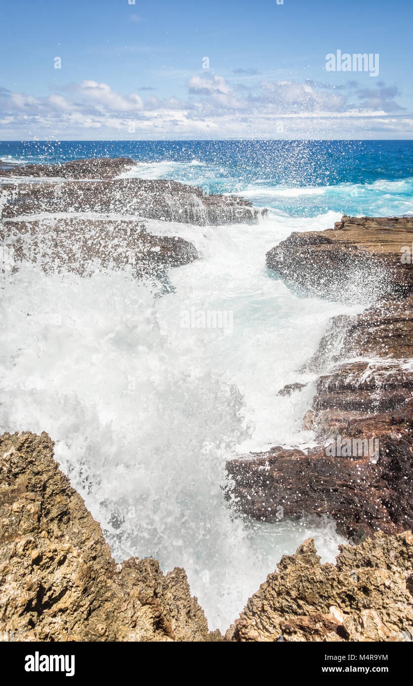 Large waves smashing through a sharp, rocky inlet on the coastline of ...