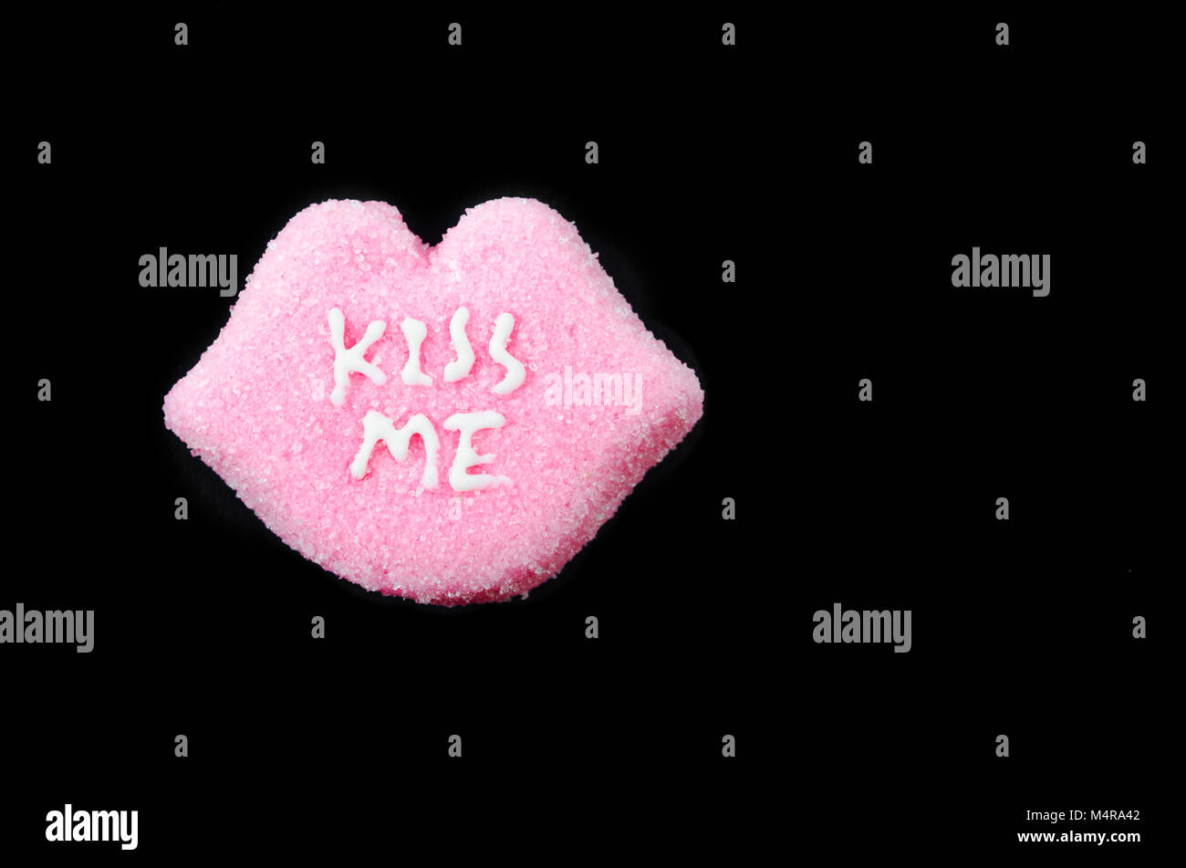 Heart shaped Valentines candies with "KISS ME" text on black background ...