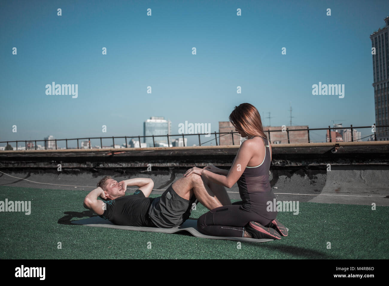 young woman helping man with situps Stock Photo - Alamy
