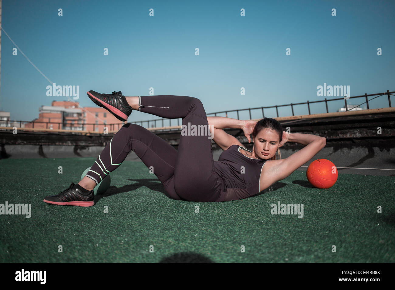 Fitness on the rooftop, woman doing sit ups rising legs Stock Photo - Alamy