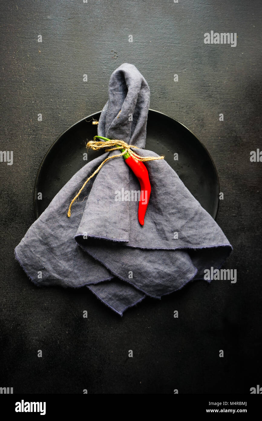 Table setting with red hot chili pepper on dark wooden table with copy ...