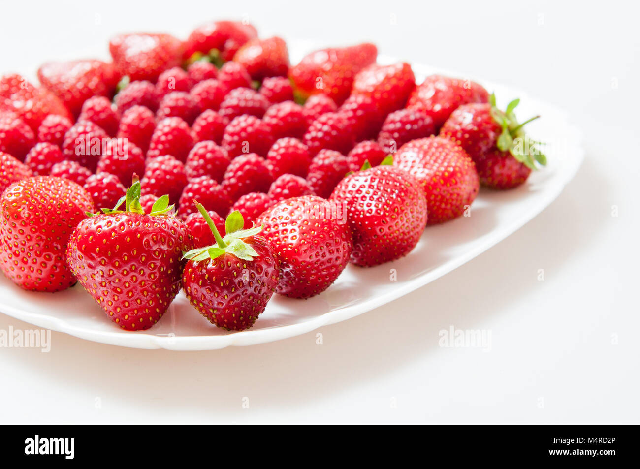 fresh raspberries and strawberries on a white plate Stock Photo - Alamy