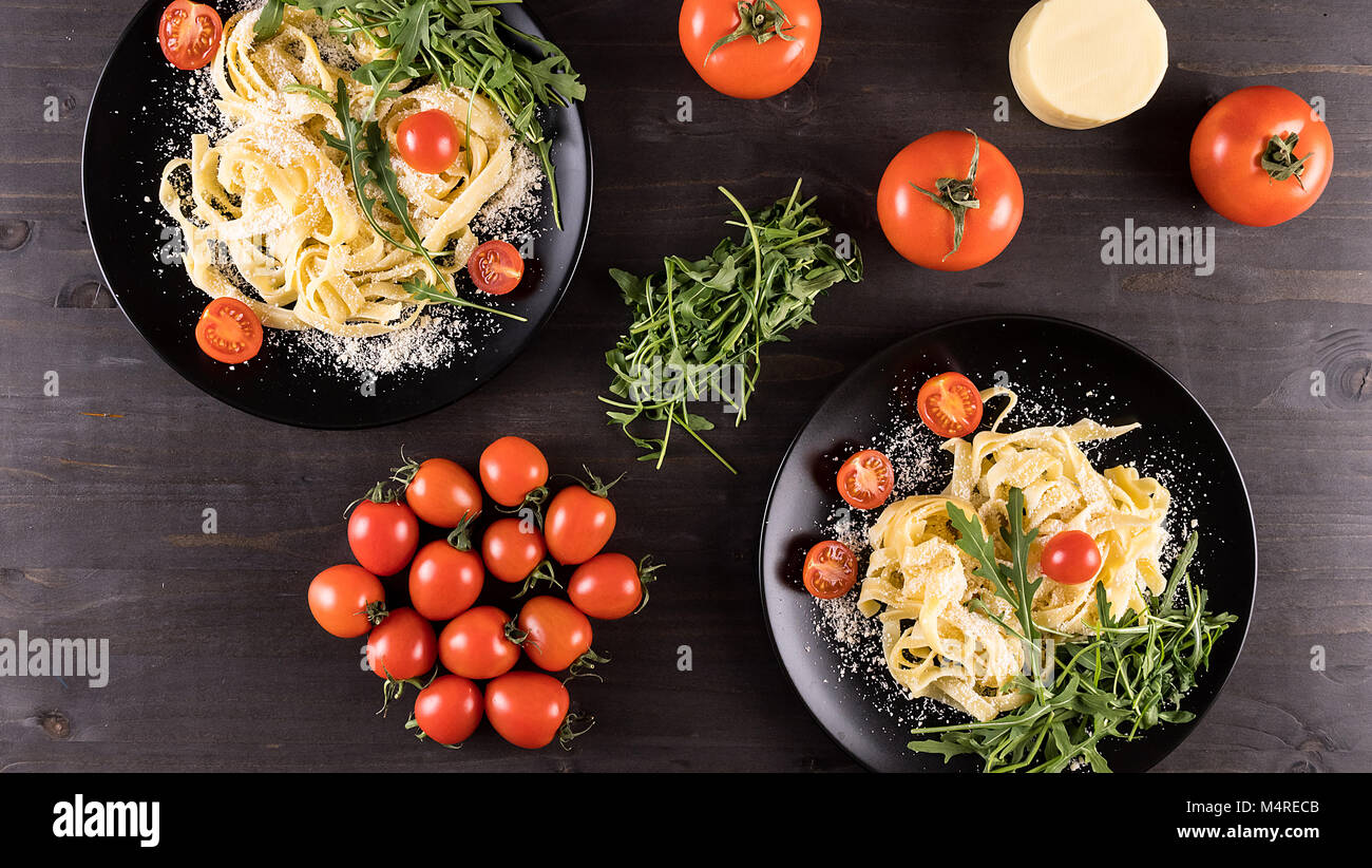 Top view on black plates with pasta Stock Photo - Alamy