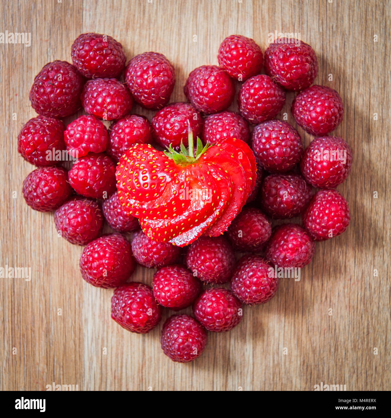 Raspberry berries heart symbol on wooden texture. Valentines day ...