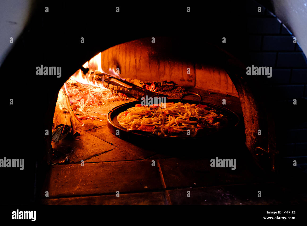 Brick oven with hot homemade pizza cooking inside Stock Photo - Alamy