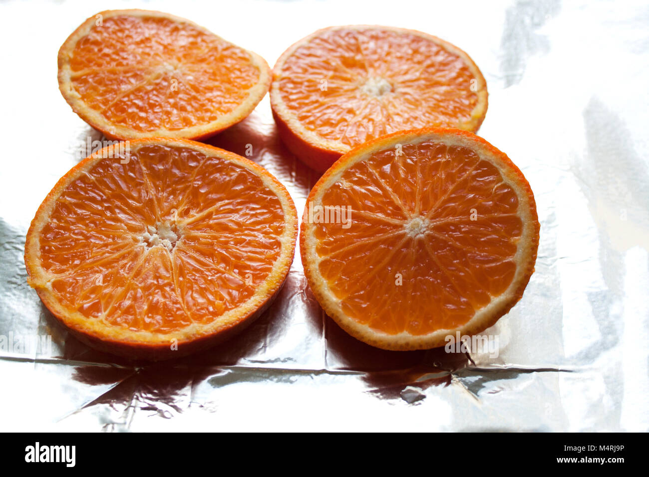 Sliced mandarin orange fruit isolated on glossy surface Stock Photo - Alamy