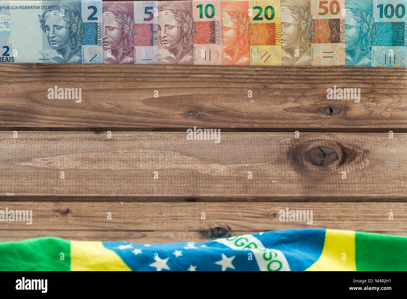 brazilian money and flag on wooden background with space for ...