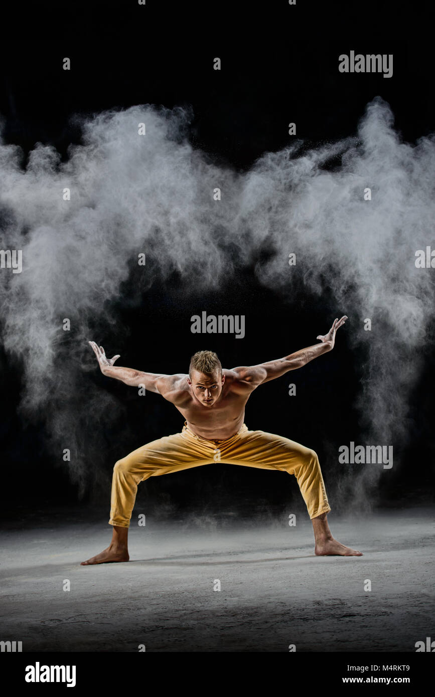 Dancing man in the dark in cloud of dust. Exhibition and staging photo ...