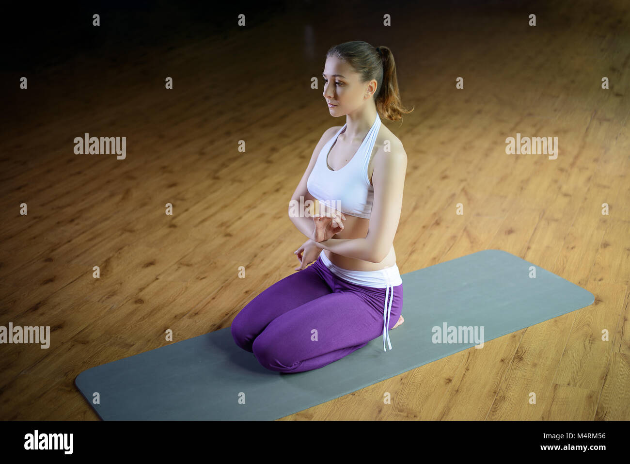 Beautiful athletic young female make yoga virasana or hero pose with ...