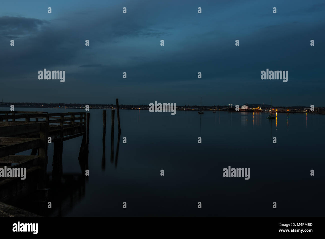 An aged dock at night with city light in the background on Bellingham ...