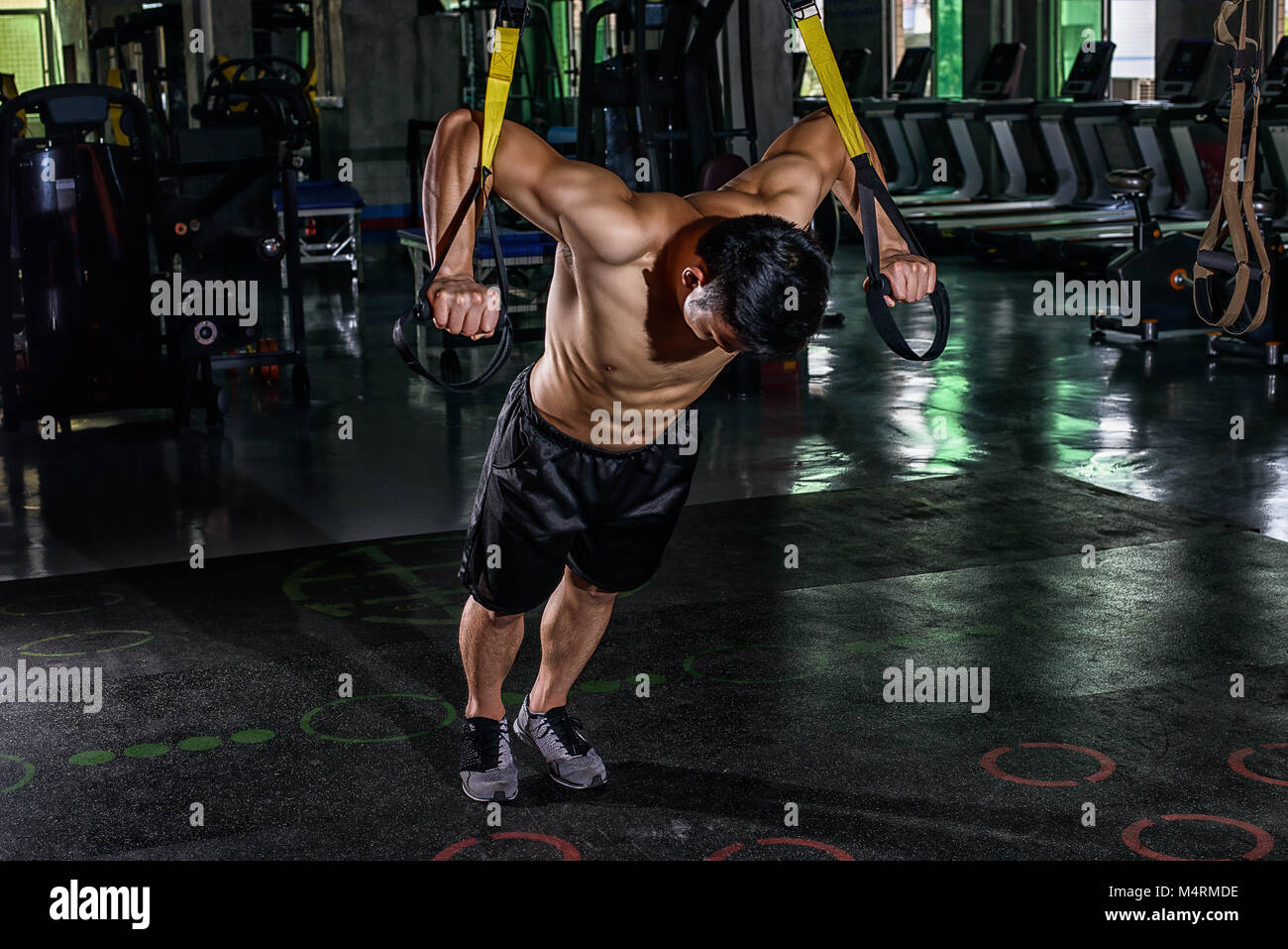 Young Chinese athletic man training with TRX Stock Photo - Alamy