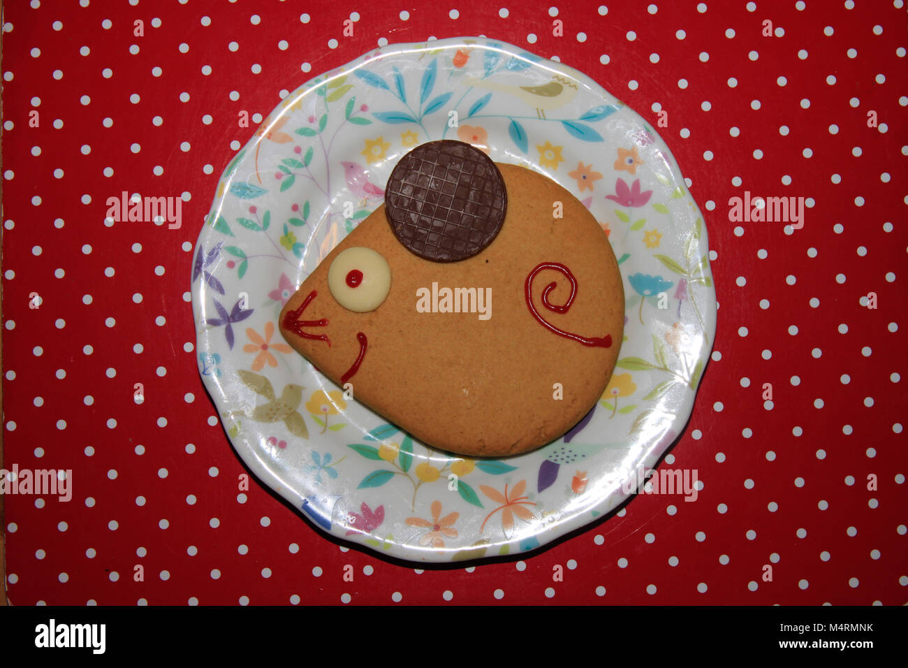 Decorated festive shortbread biscuits on tea plates on red spotty ...