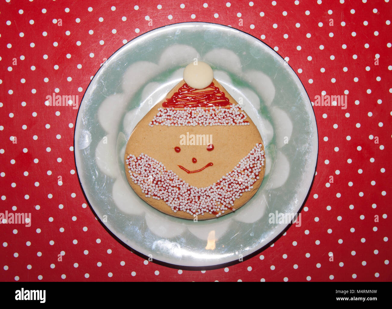 Decorated festive shortbread biscuits on tea plates on red spotty ...