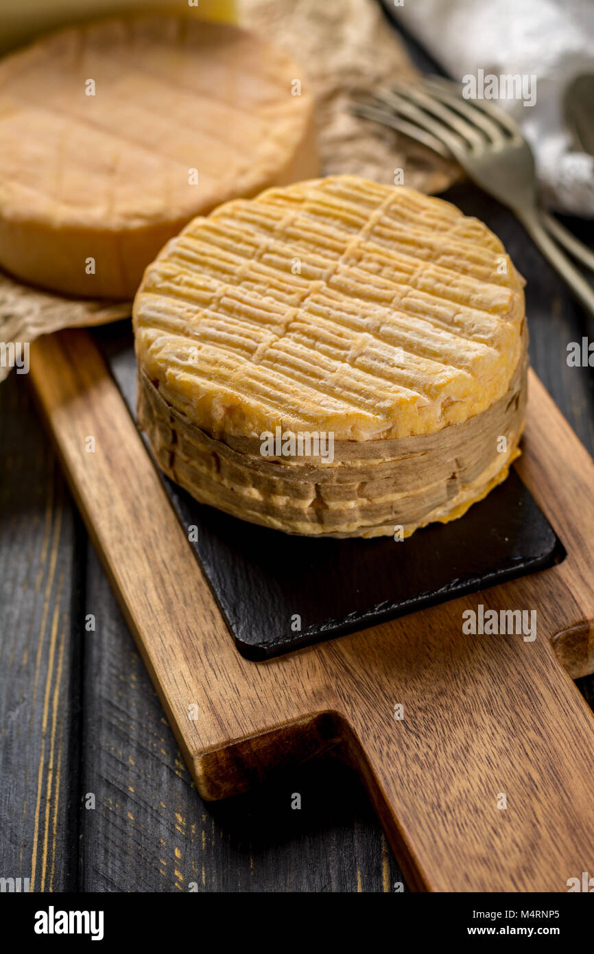 Tasting of French cheese Livarot, close up, on wooden background Stock ...